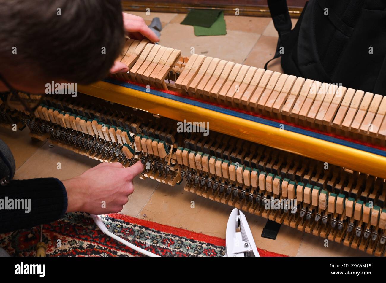 A male piano tuner performs piano repairs Stock Photo - Alamy