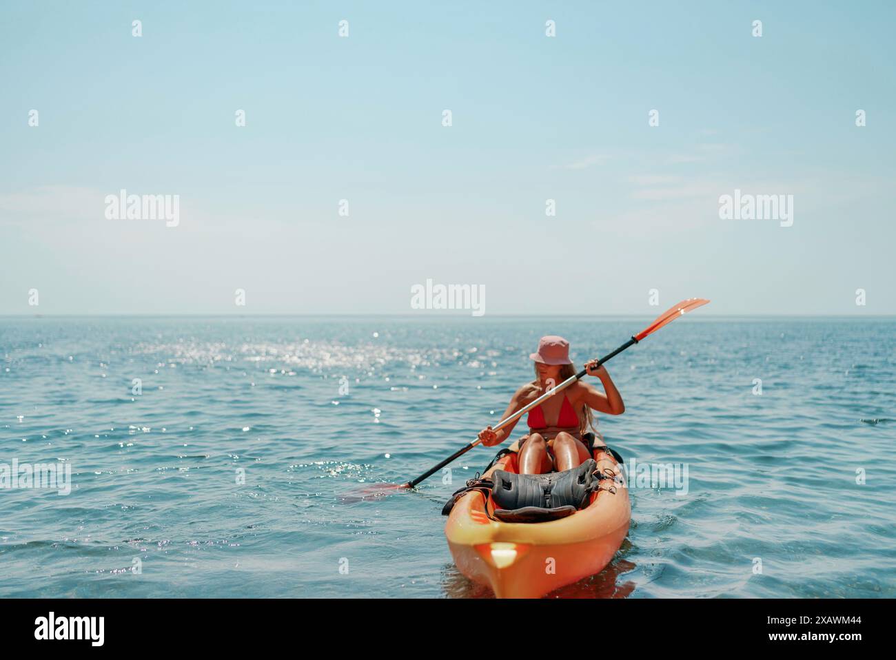 Kayak sea woman. Happy attractive woman with long hair in red swimsuit ...