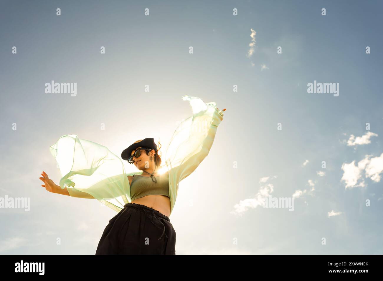 woman with scarf, handkerchief, cap and sunglasses at sunset, lens ...