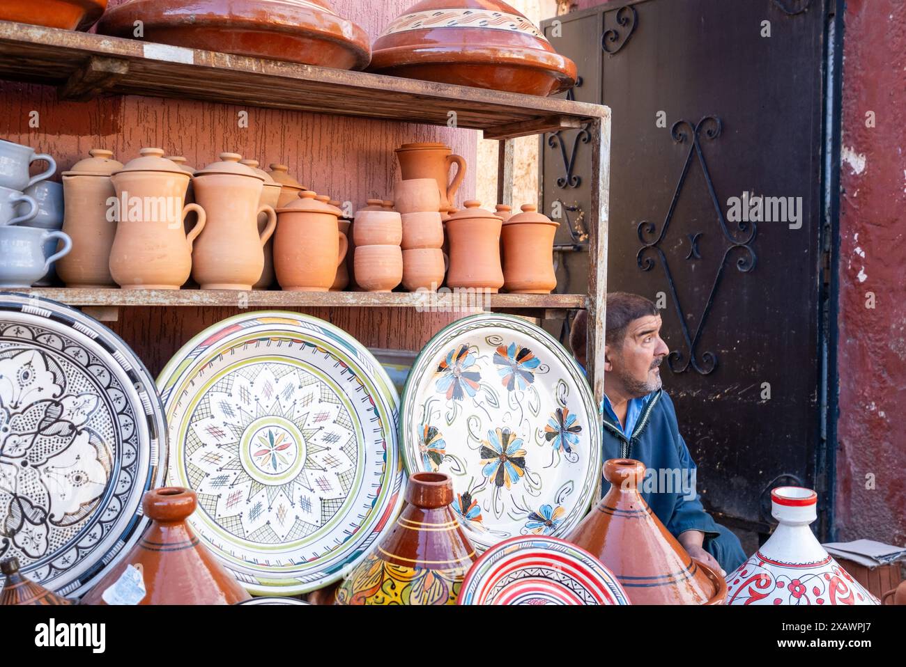 A vendor sits in front of a typical handicraft and terracotta shop ...