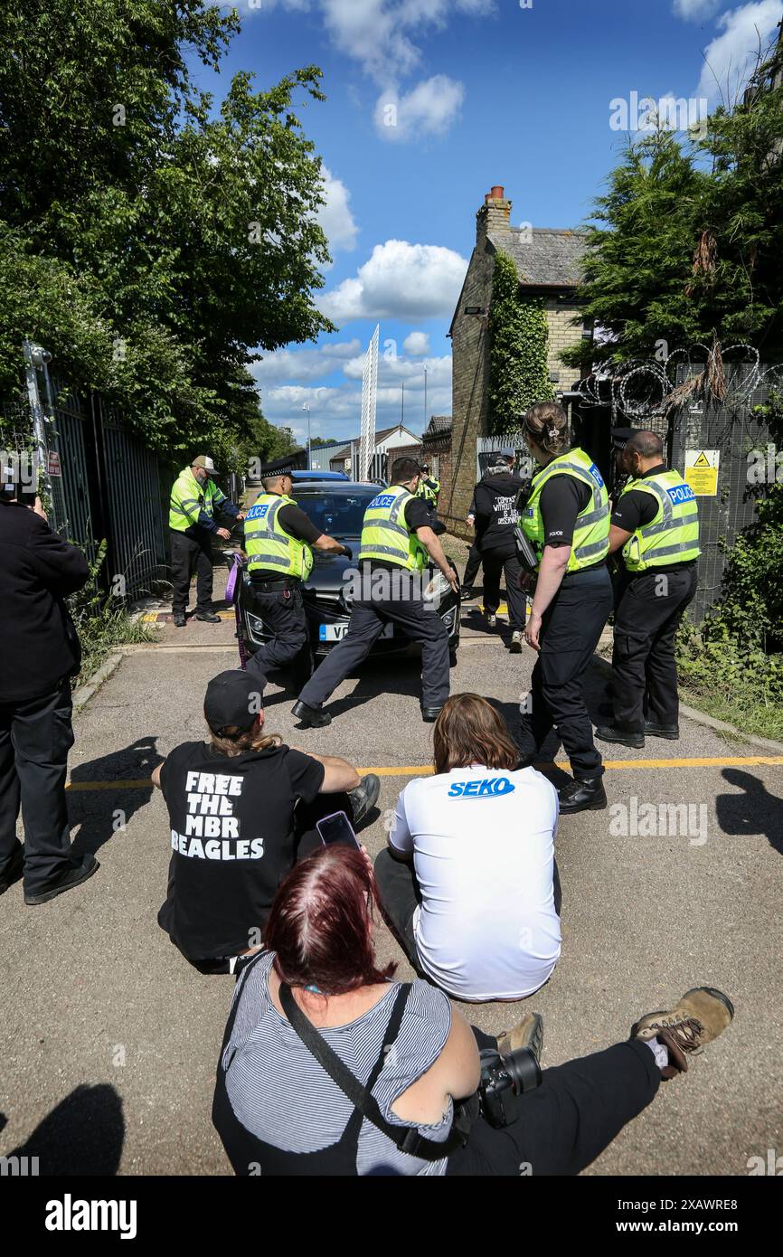 One protester makes a dash for the open gate while other protesters sit ...