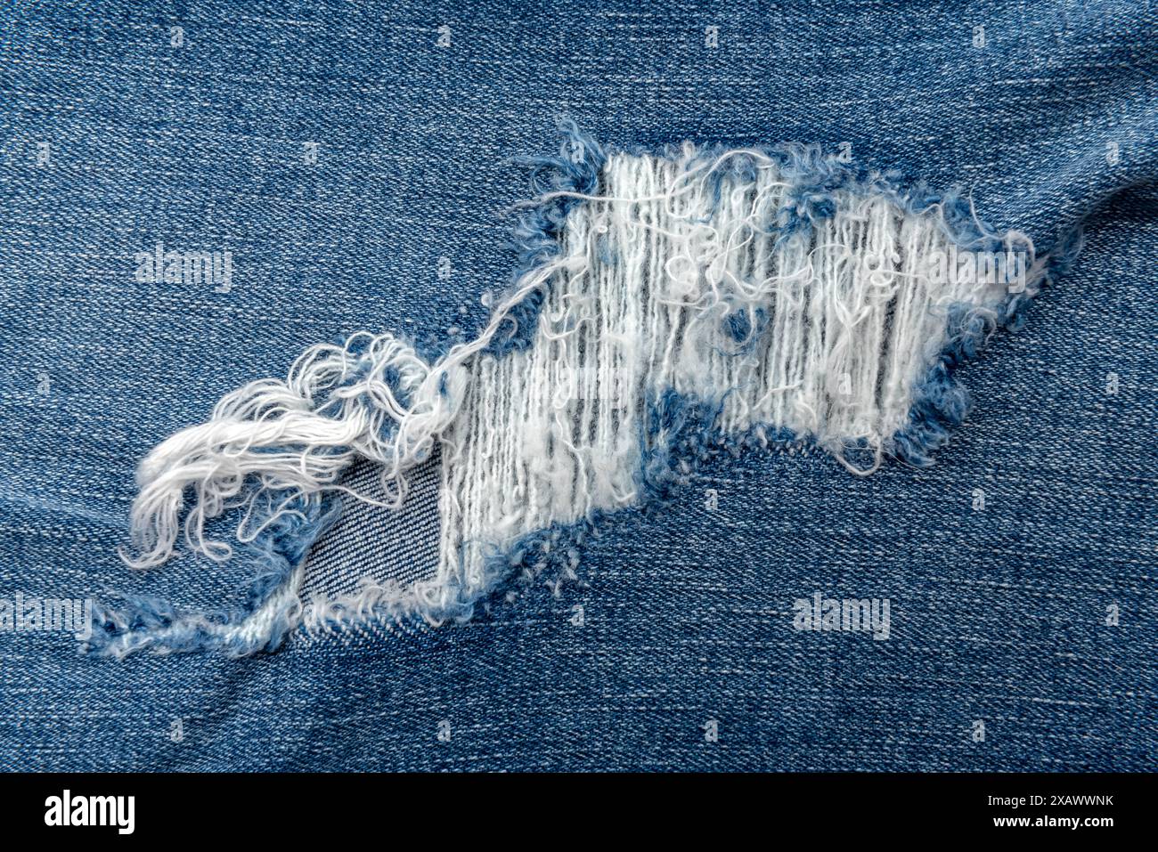 Hole in jeans close-up. Texture of faded denim Stock Photo - Alamy