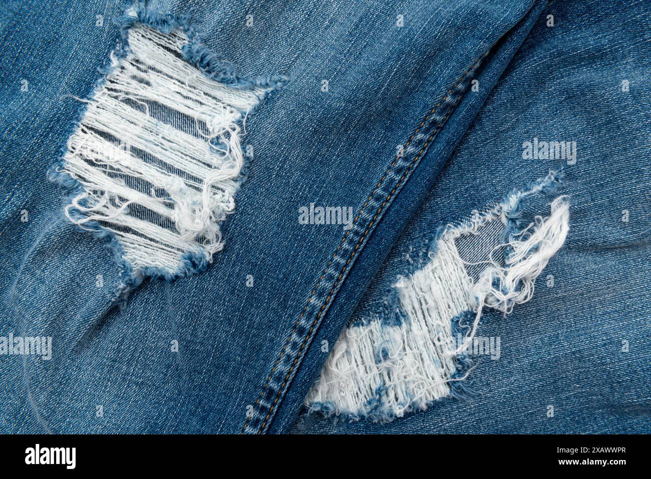 Hole in jeans close-up. Texture of faded denim Stock Photo - Alamy