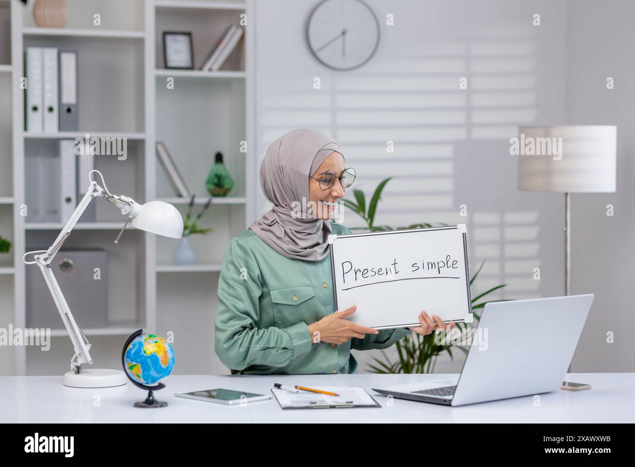 Teacher explaining present simple tense in a virtual class using a ...