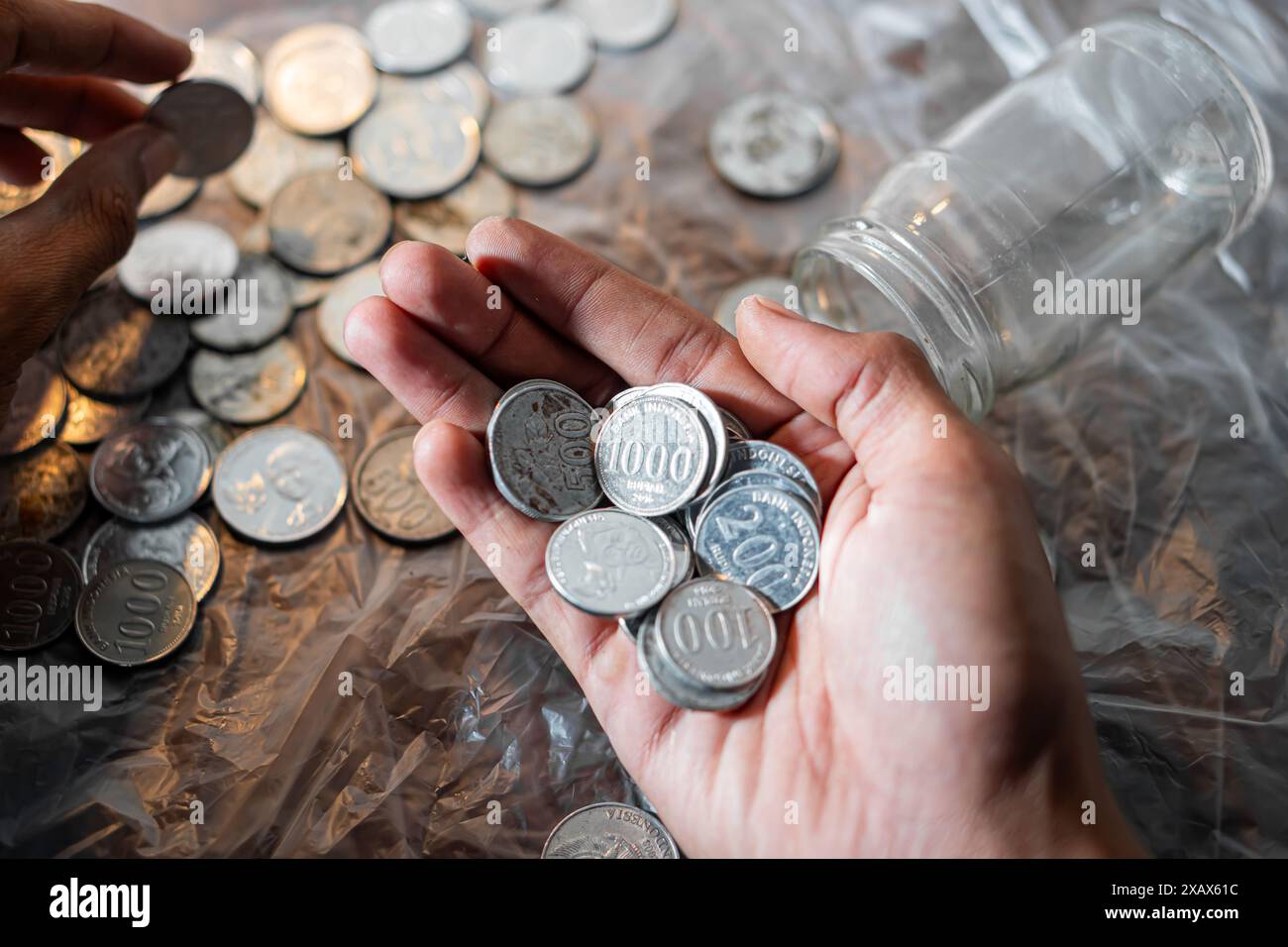 A hand holding several South Korean won coins with more coins and an ...