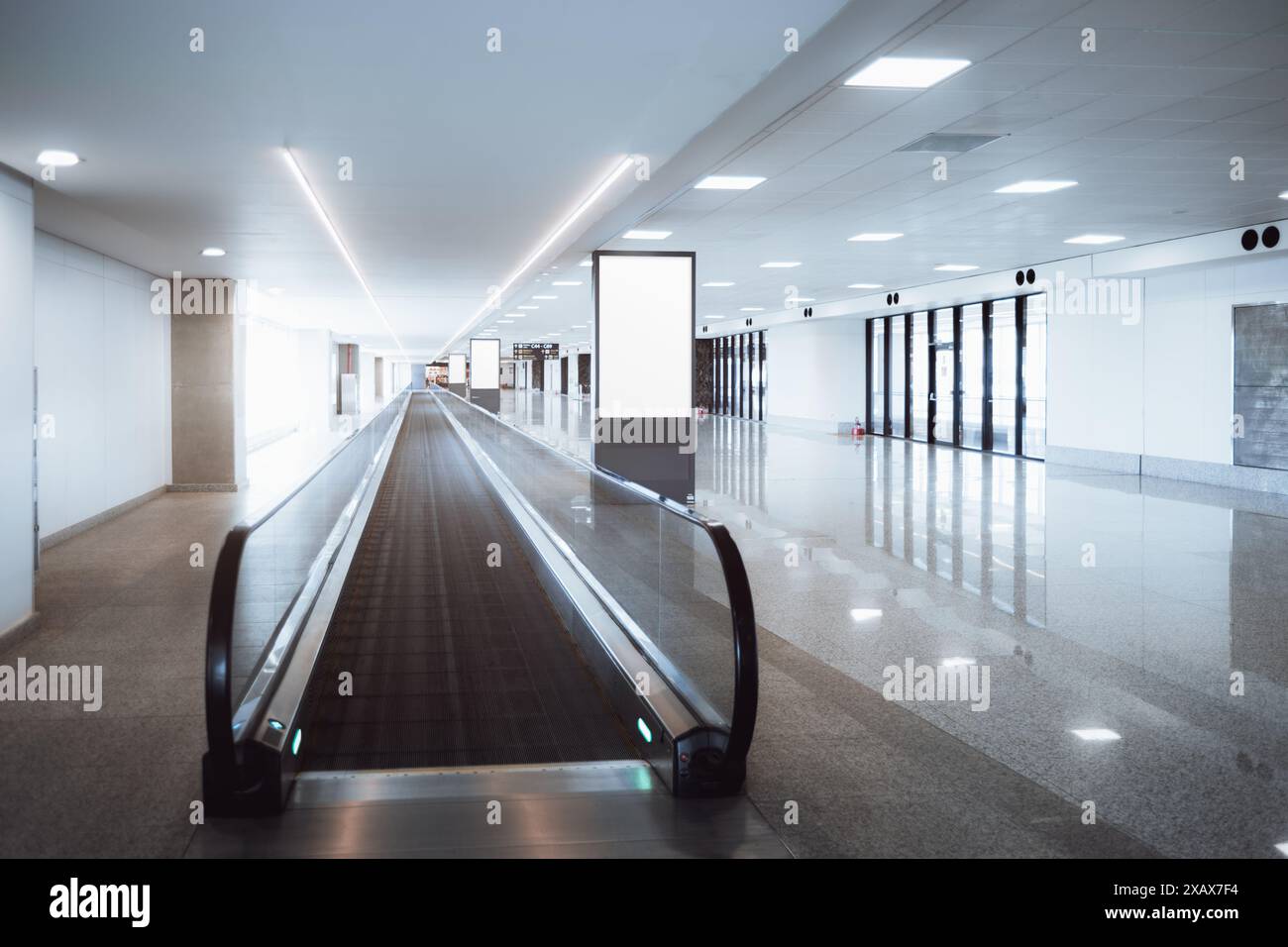 Empty modern airport terminal with a moving walkway (travelator) and ...