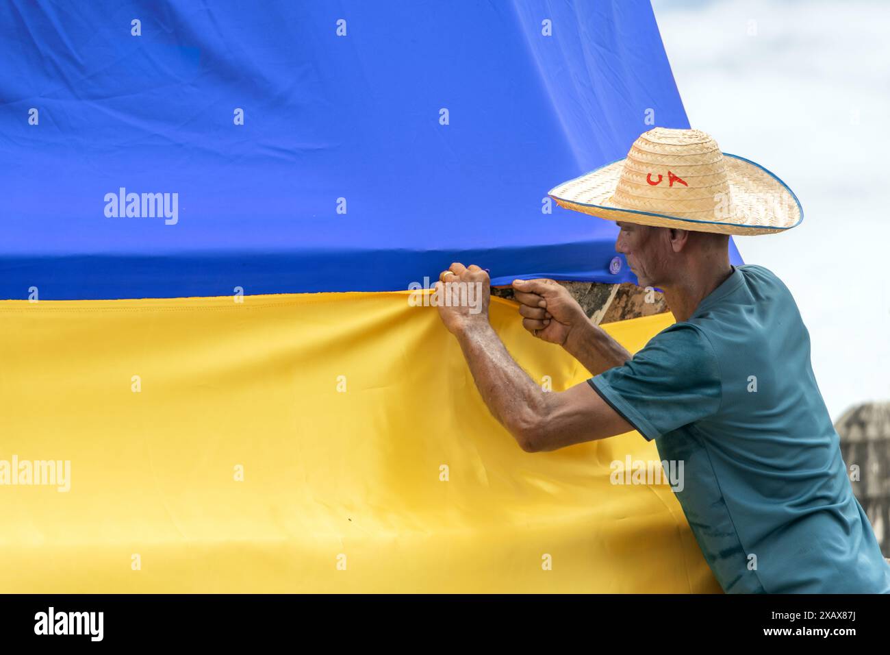 A older man decorates a building with yellow and blue textile Stock ...