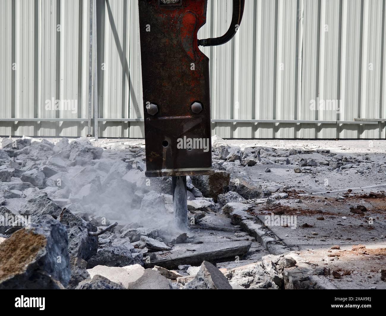 A hydraulic hammer breaking concrete at a construction site Stock Photo ...