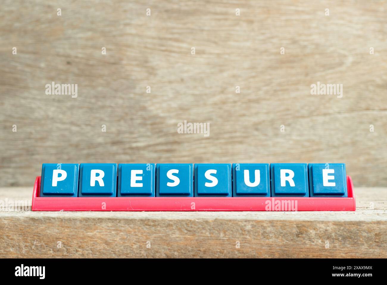 Tile letter on red rack in word pressure on wood background Stock Photo ...