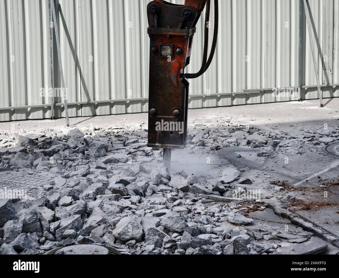 A hydraulic hammer breaking concrete at a construction site Stock Photo ...
