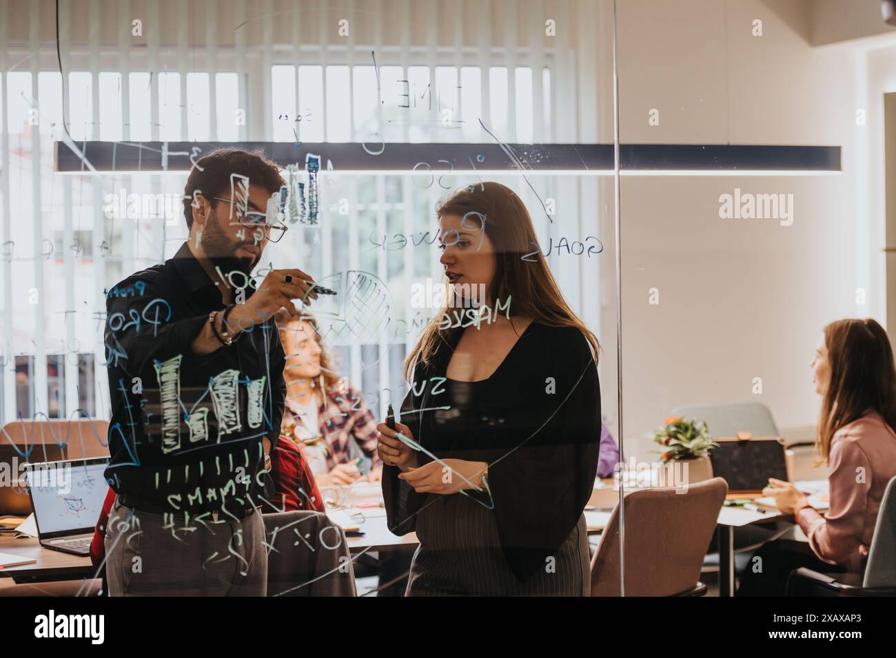 Creative business team engages in brainstorming session using glass ...