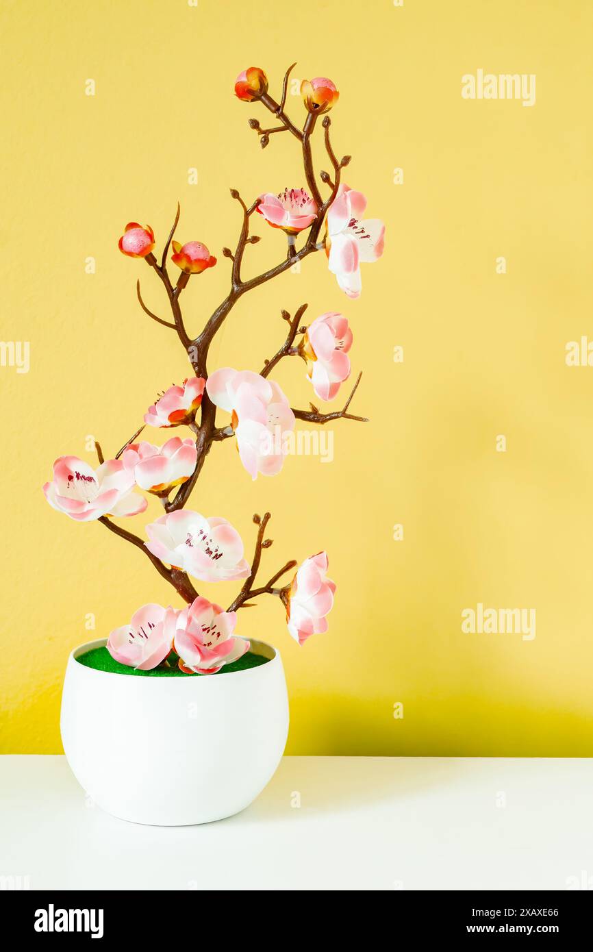 Artificial Japanese sakura plant in a white pot in front of a green ...