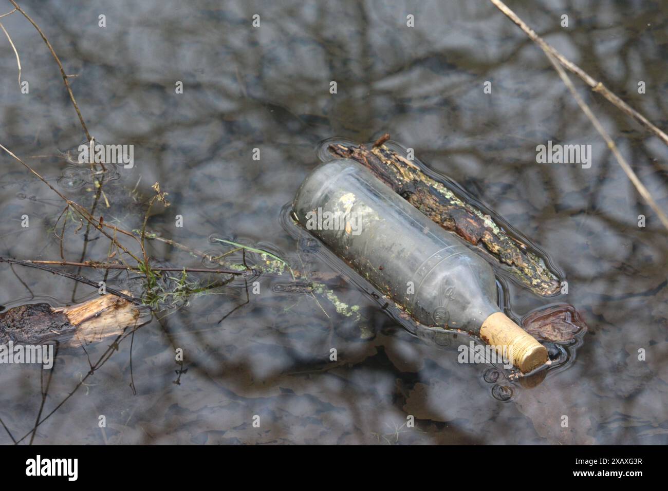 A photograph of a bottle discarded bottle as rubbish in canal water. Polluted water Stock Photo ...