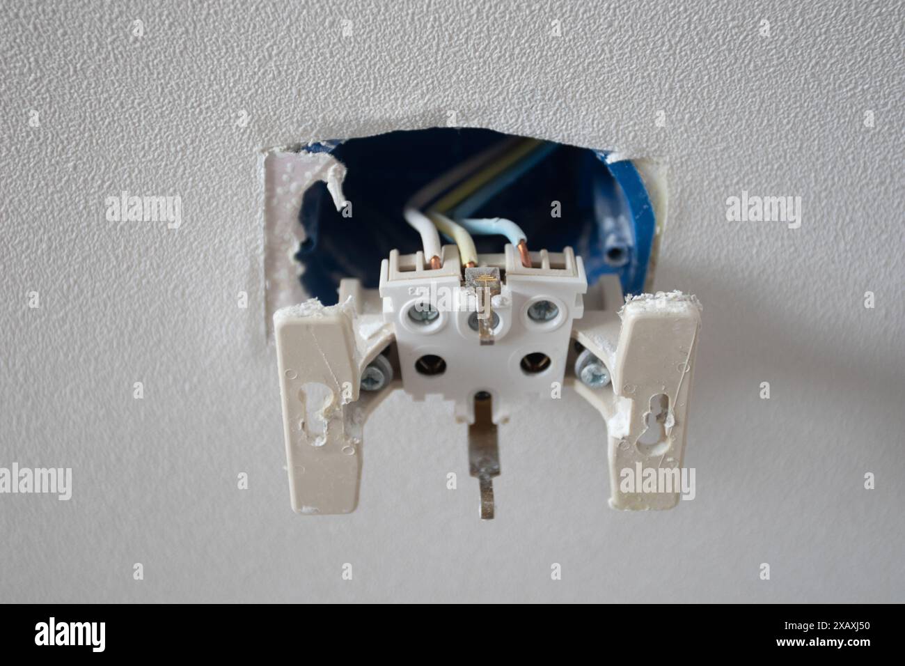 Electrical wires sticking out from electrical socket hole Stock Photo ...