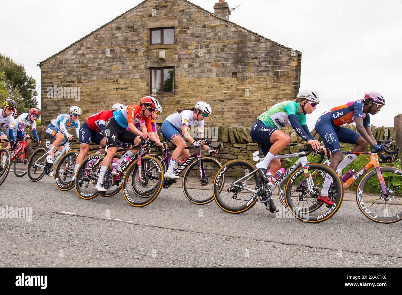 Delph, UK, 9 June 2024. The peloton descending from Grains Bar during ...