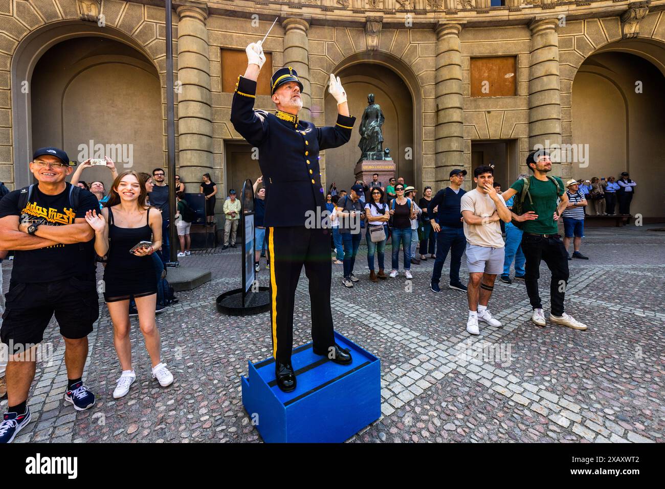 The conductor of the cavalry band stands on a platform in the middle of ...