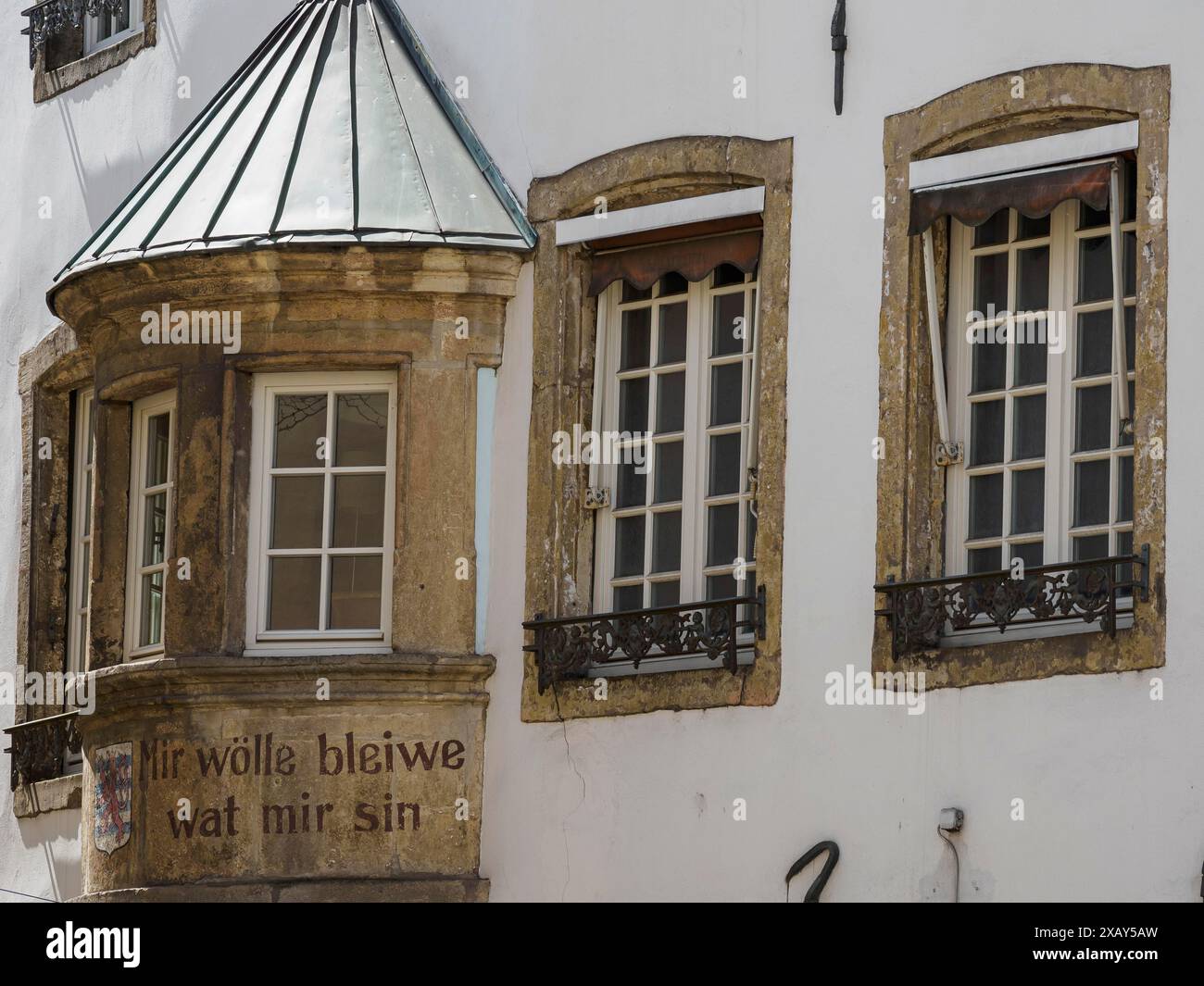 Historic facade with bay window and inscription, rustic stone frames ...