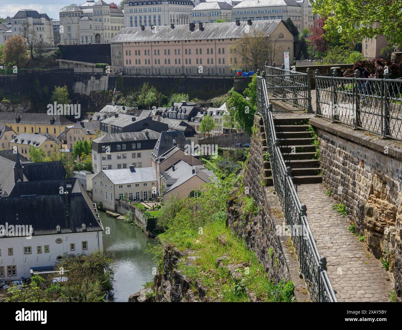 View of a historic city with houses, a river and lots of greenery ...