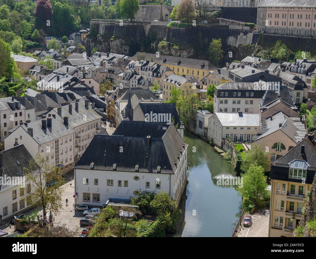 Old town scene with narrow houses, a river and wooden hills in the ...