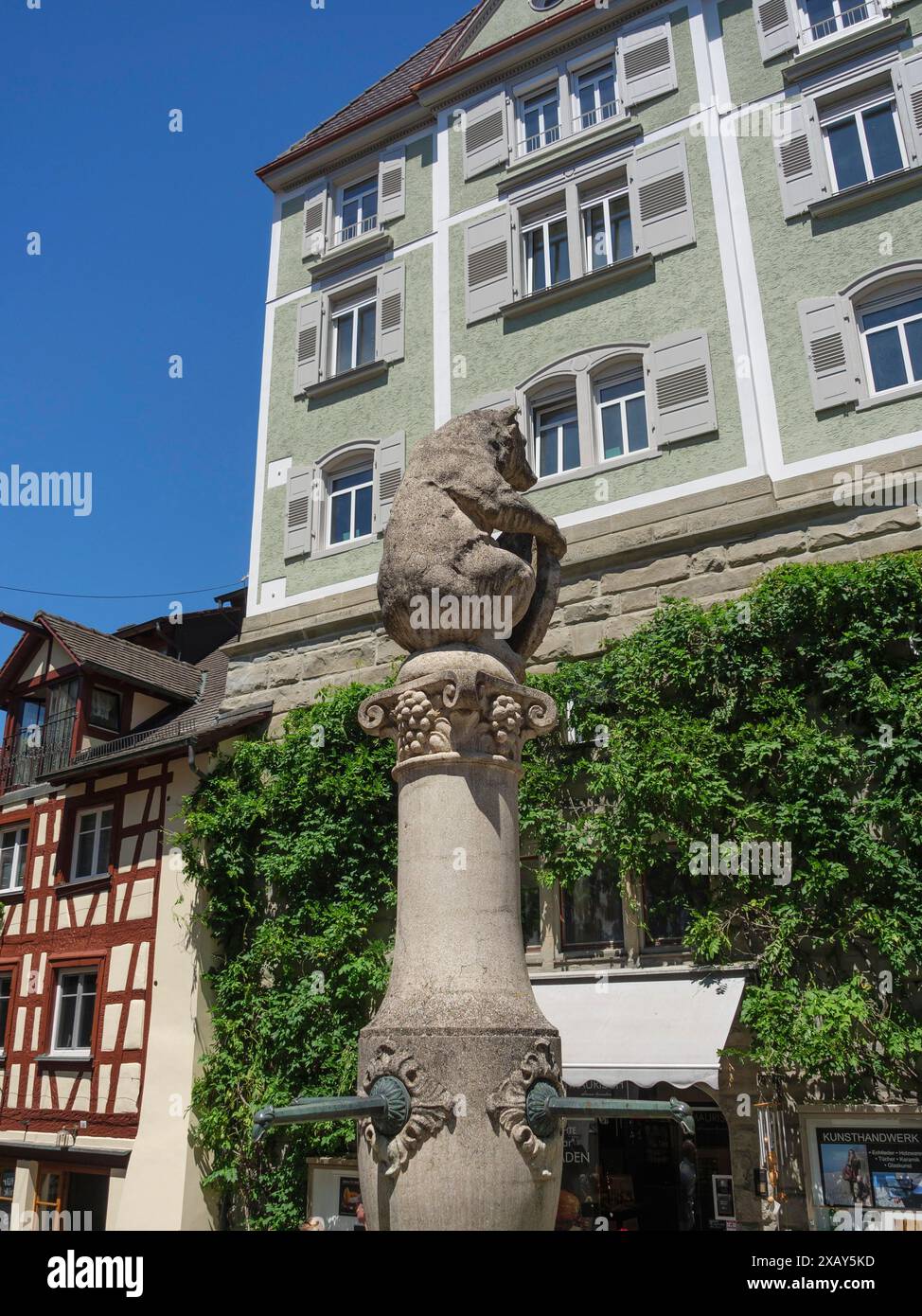 Statue on a column in front of historic buildings with green facades ...