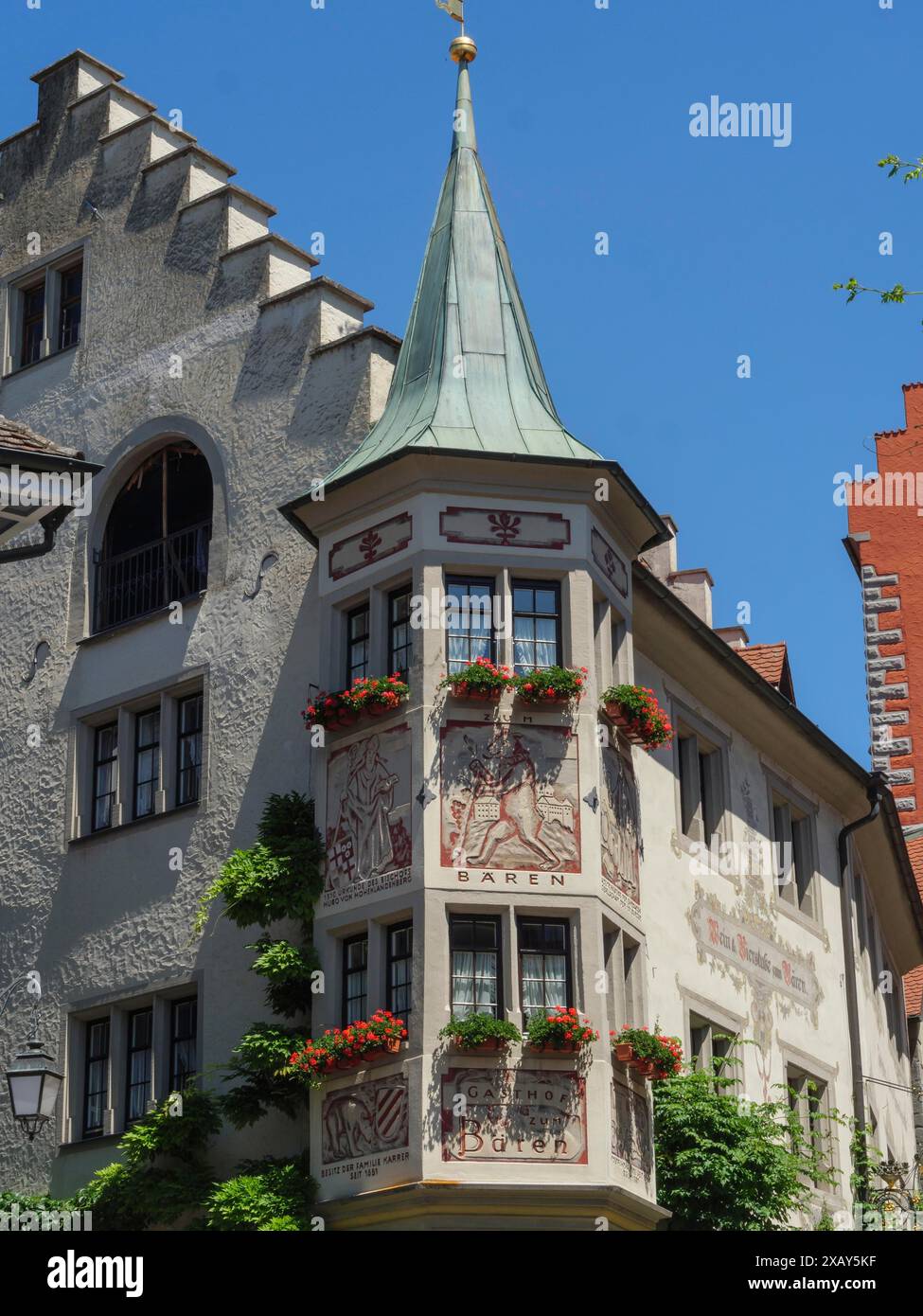 A historic building with a pointed tower and murals, decorated with ...