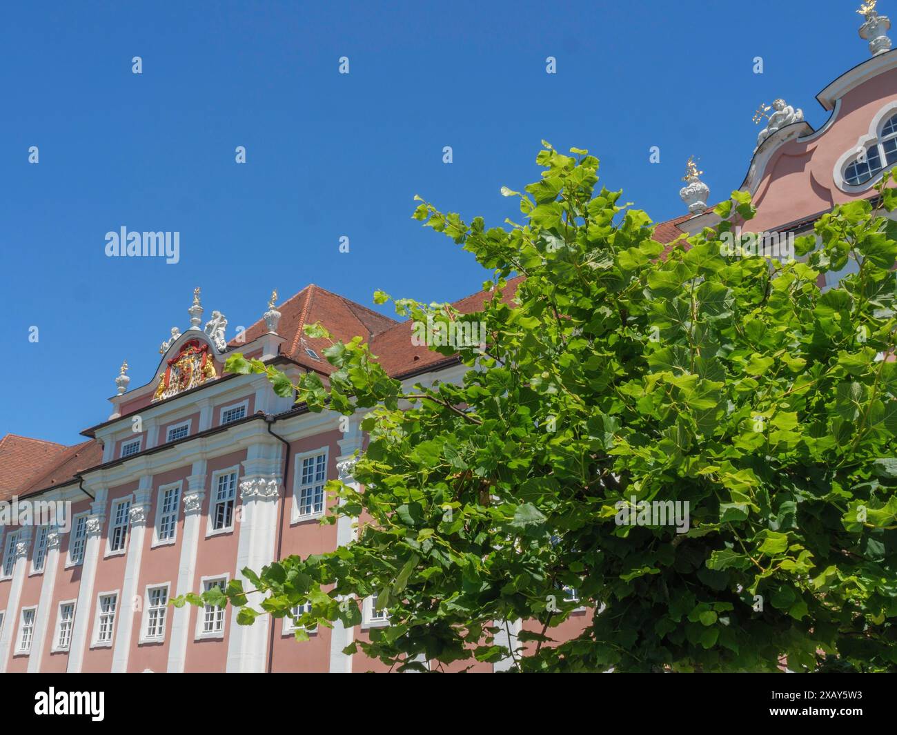 Part of a historic building with trees and garden under a clear blue ...