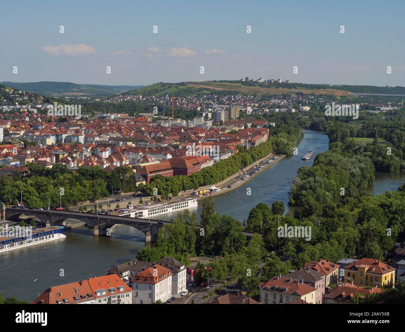 A sweeping panorama of a historic city with red roofs, crossed by a ...