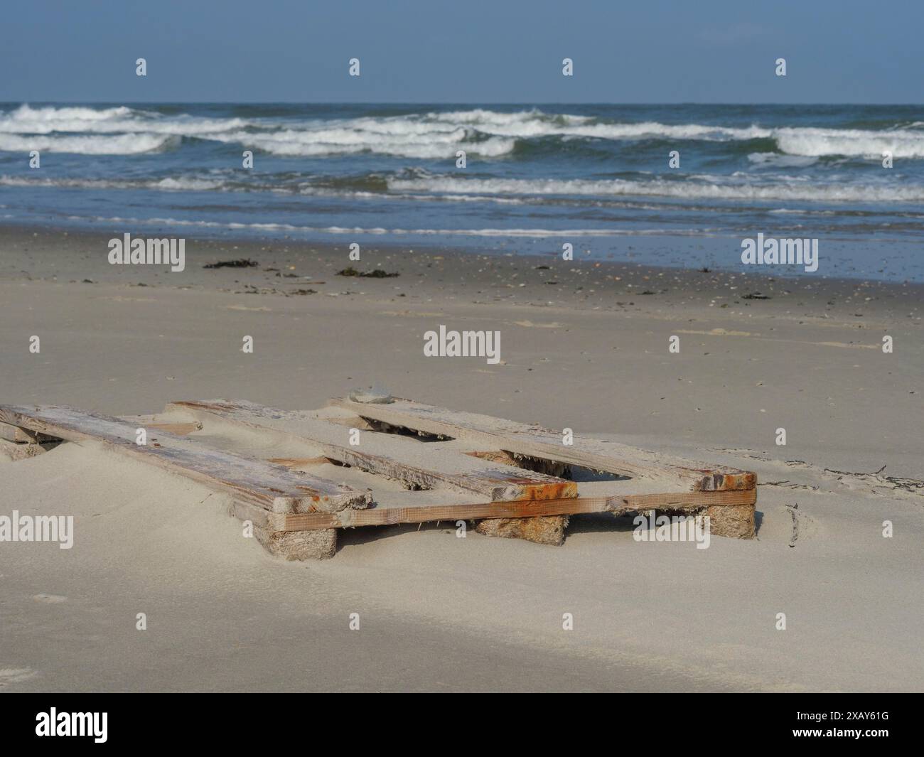 Old wooden pallets lying on the beach, with waves of the sea in the ...