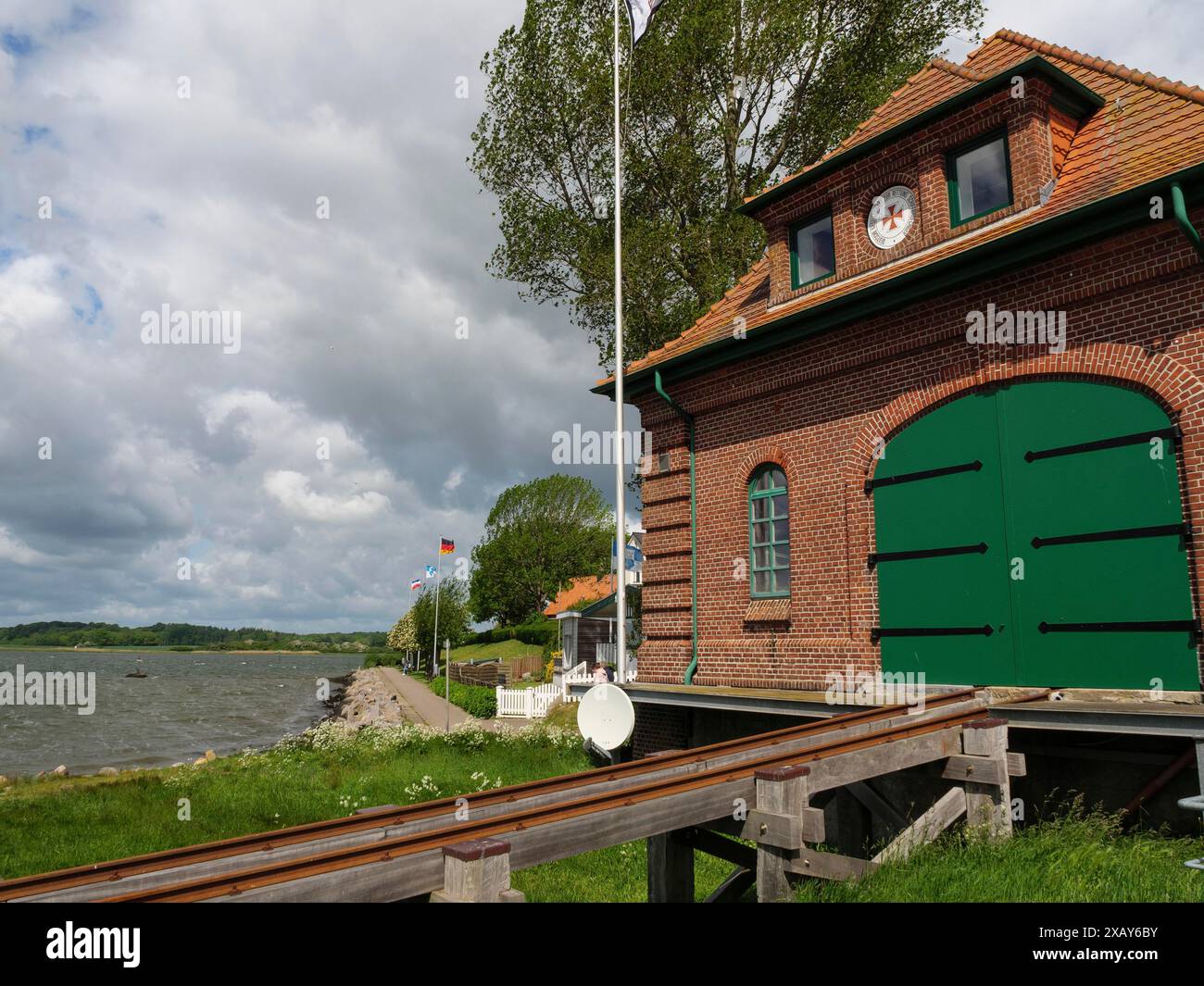 Red brick building with green Tor tor on the waterfront with railway ...