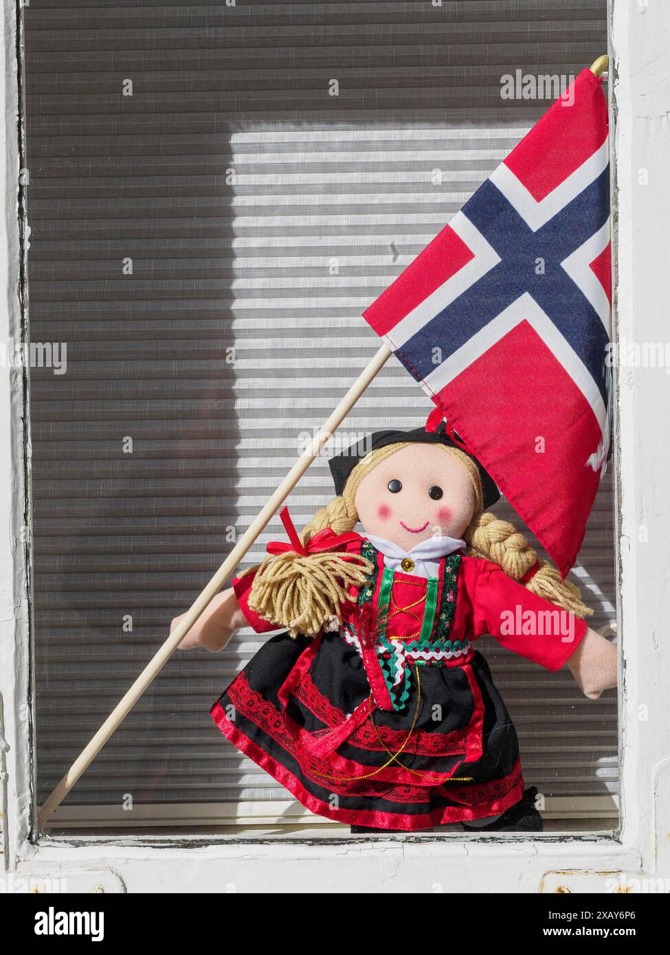 A doll in traditional traditional costume holds a Norwegian flag and ...