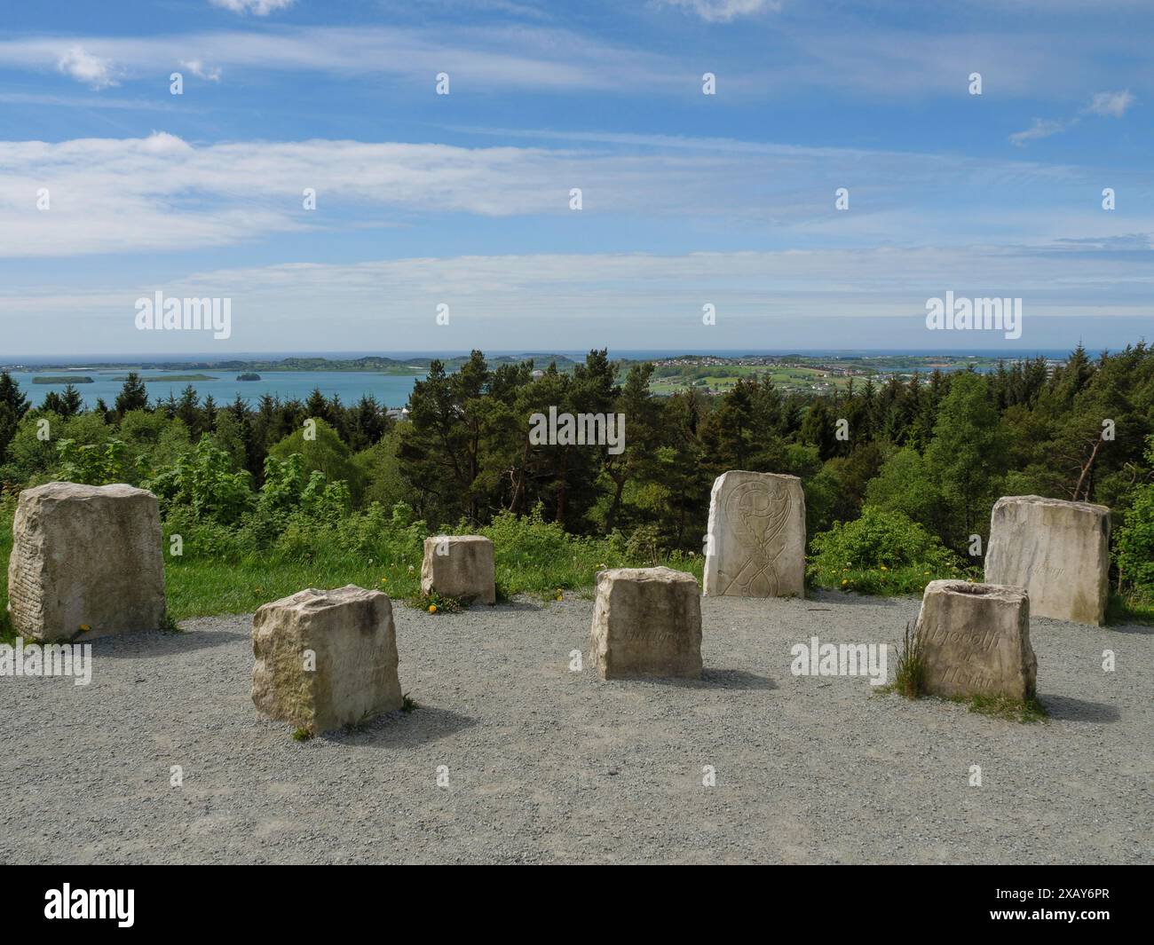 Stone monuments on a hill overlooking a wooded landscape and blue sky ...