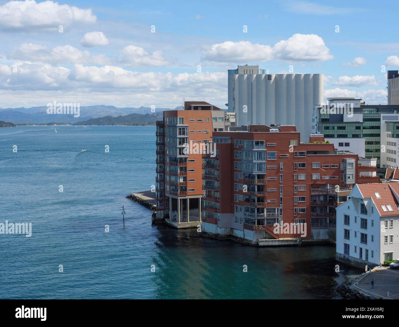 Modern residential building on the waterfront with blue sky and clouds ...