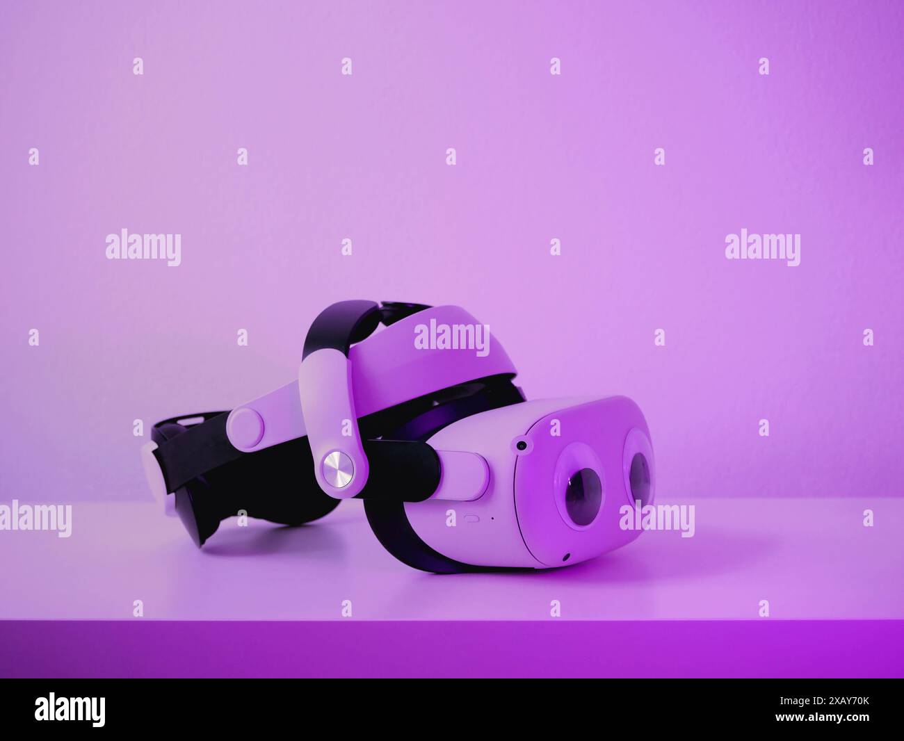 VR virtual reality glasses helmet with eye stickers, lying on a white ...