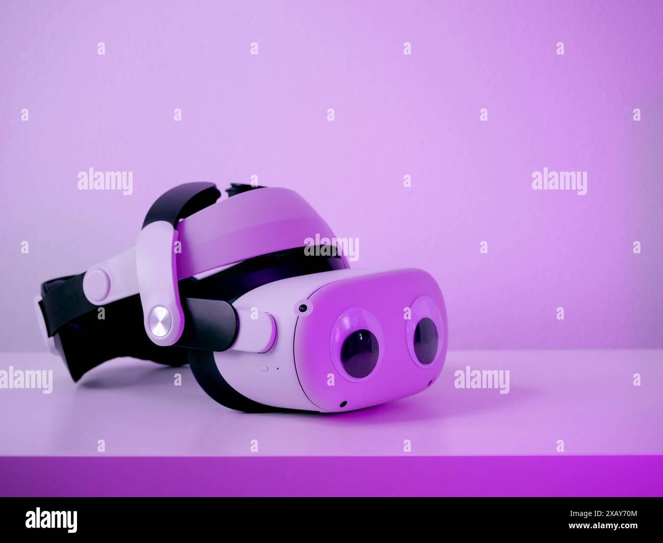 VR virtual reality glasses helmet with eye stickers, lying on a white ...