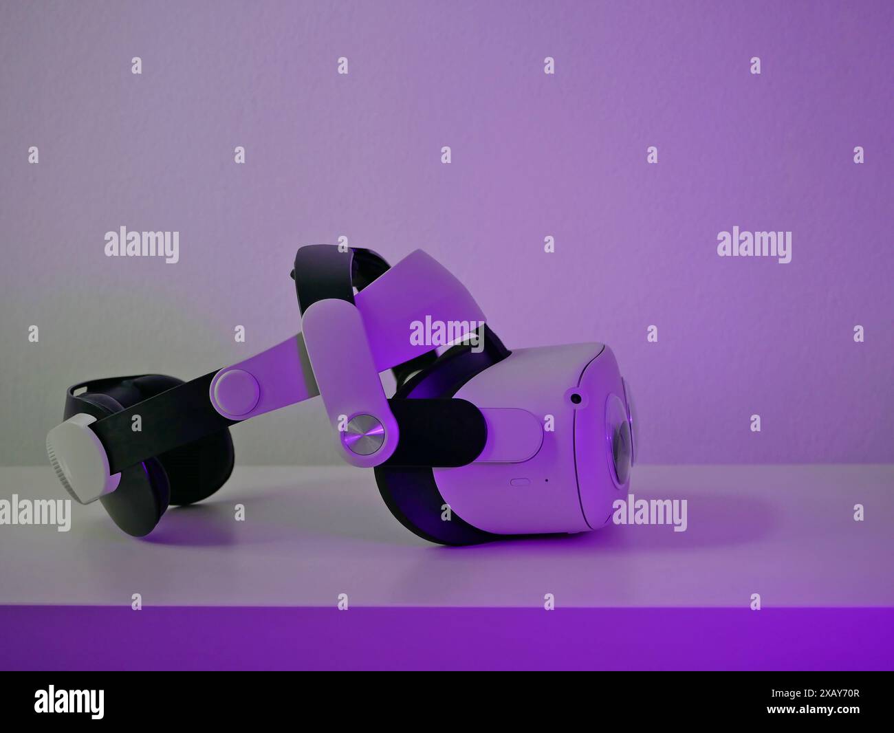 VR virtual reality glasses helmet, lying on a white table in violet ...