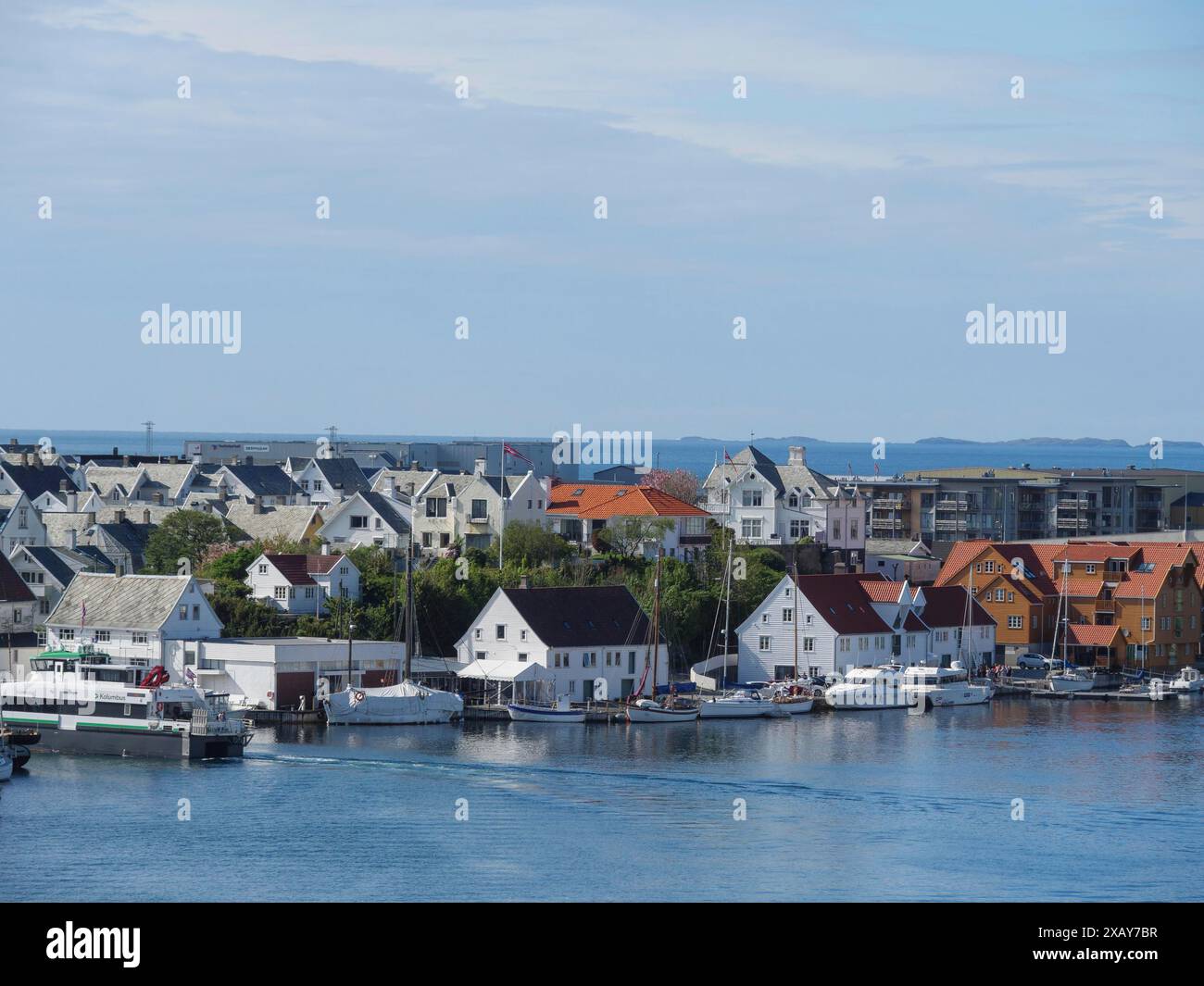 Harbour town with modern and traditional houses along the coast, boats ...