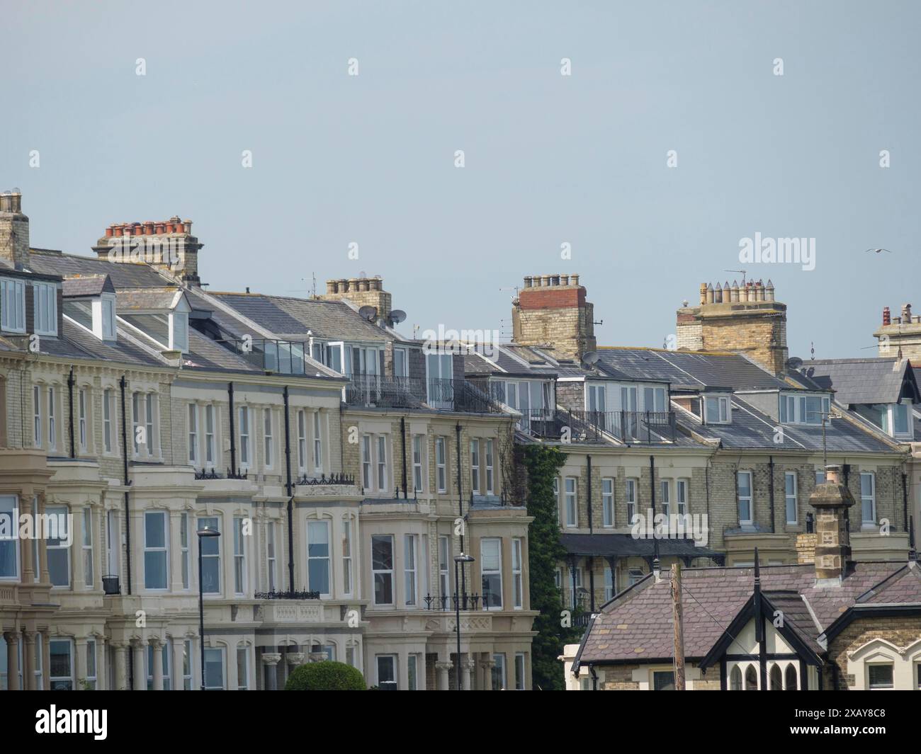A row of townhouses with large windows and skylights in an urban area ...