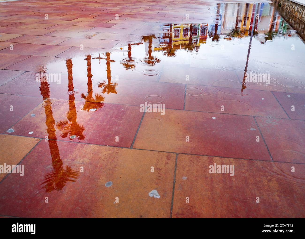 Reflections of the houses in the puddles on the beach promenade in ...