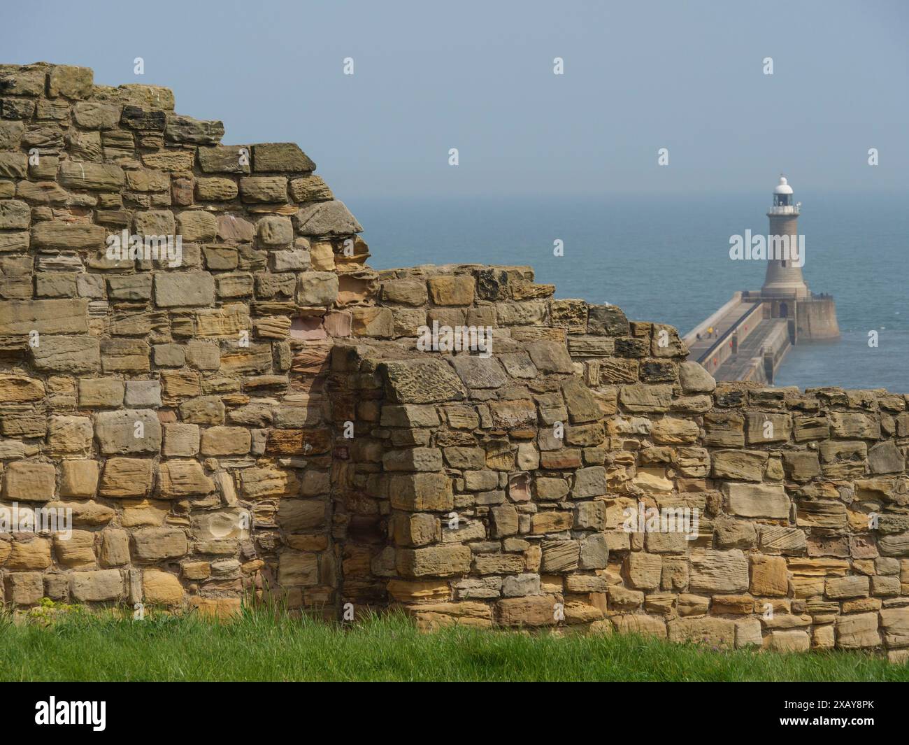 Partly dilapidated stone wall of a ruin with a view of the sea and a ...