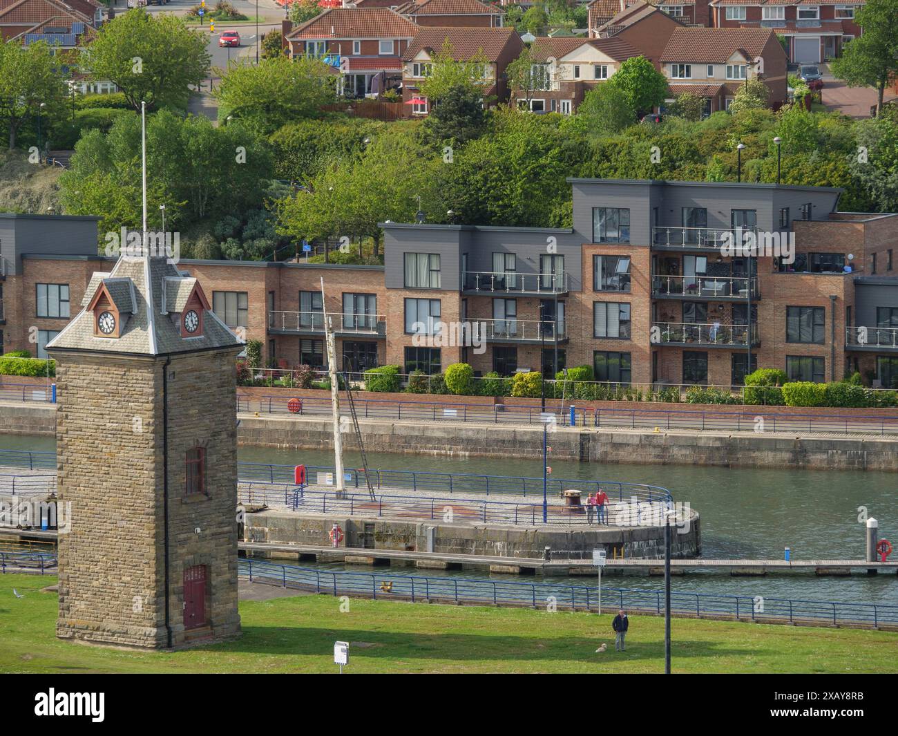 Stone tower on the riverside with modern residential buildings in the ...