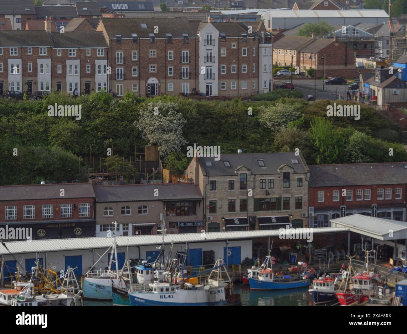 A view of a harbour area with fishing boats and town buildings in the ...