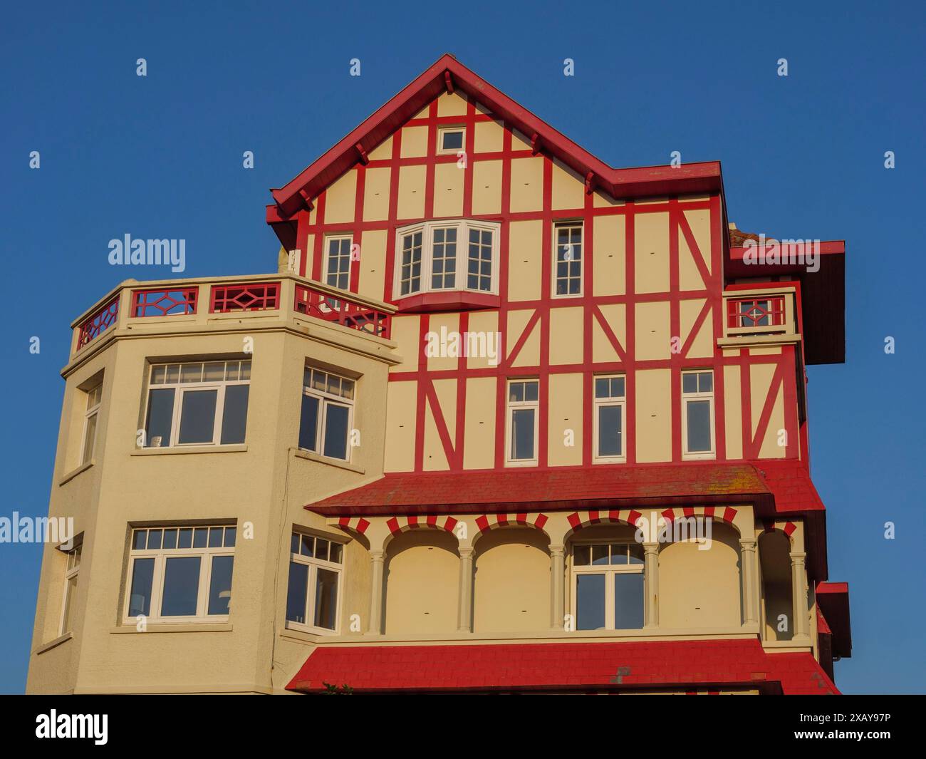 Multi-storey half-timbered house in red and beige with blue windows ...