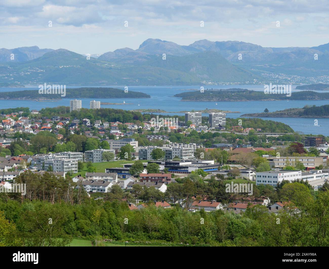 Panorama of a city with surrounding sea and mountains under a partly ...
