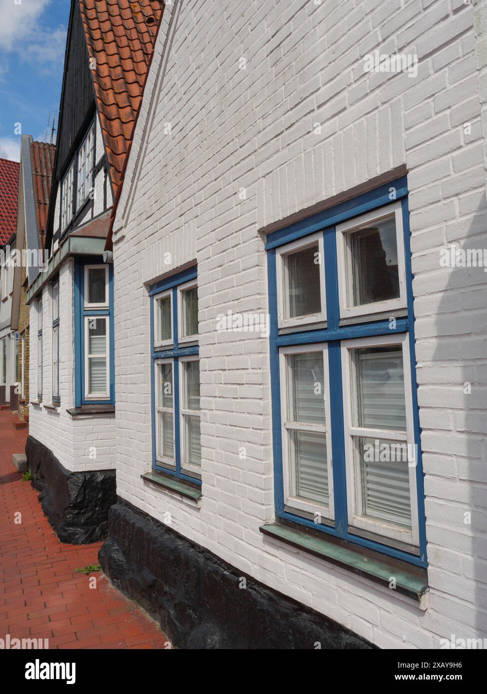 Close-up view of white houses with blue window frames and tiled roofs ...