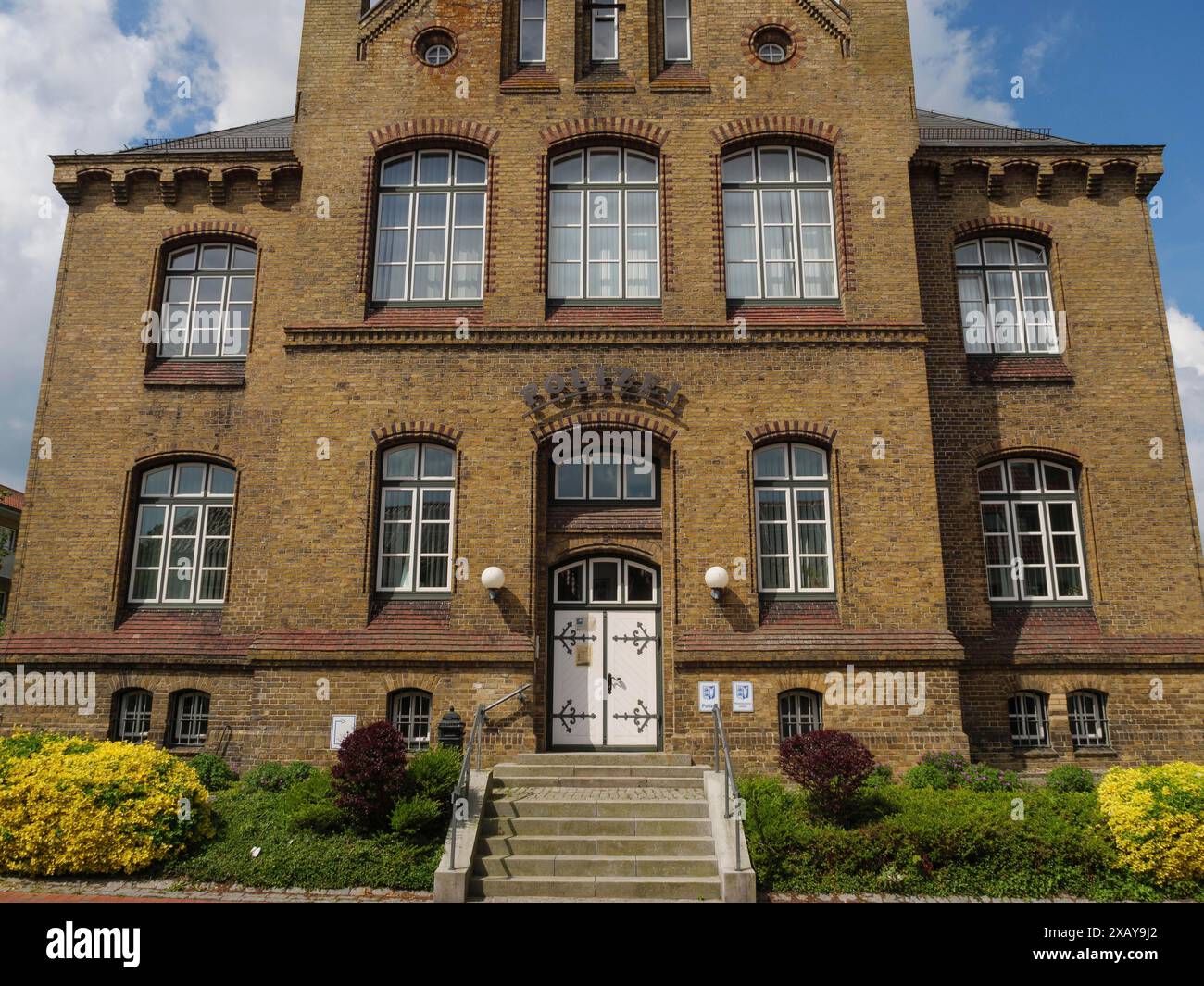 Historic brick building with numerous windows and stairs in a well-kept ...