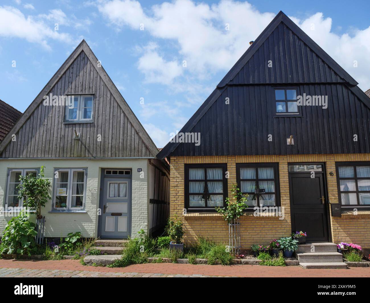 Two houses next to each other with steep pitched roofs, one with a ...