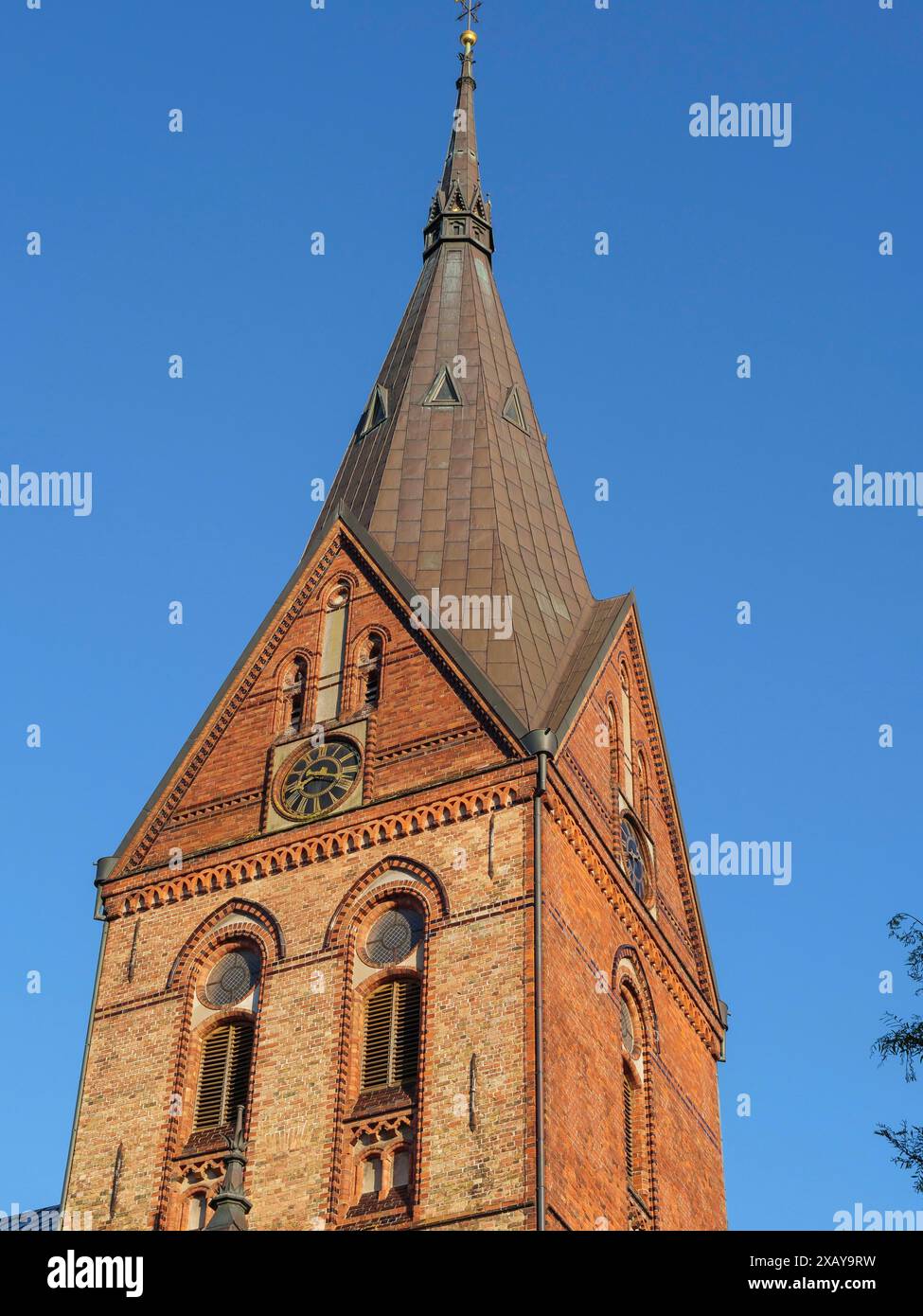 A close-up of a historic brick church tower under a clear blue sky ...
