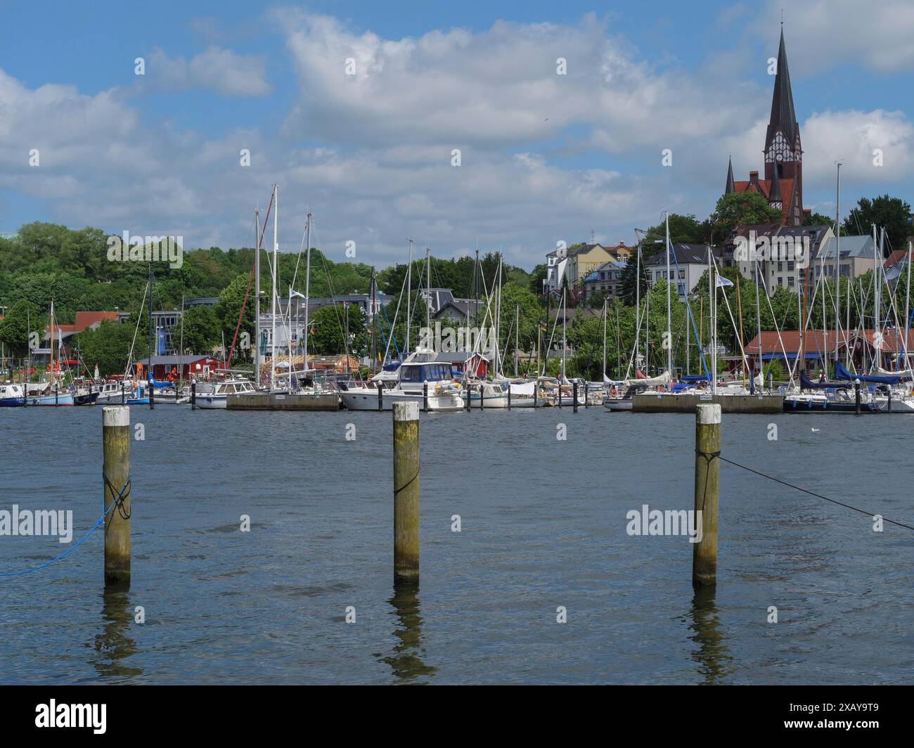 A harbour landscape with sailing boats, surrounded by traditional ...