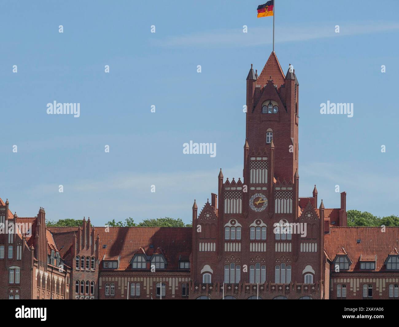 An imposing red brick building with tower and German flag, symbolising ...