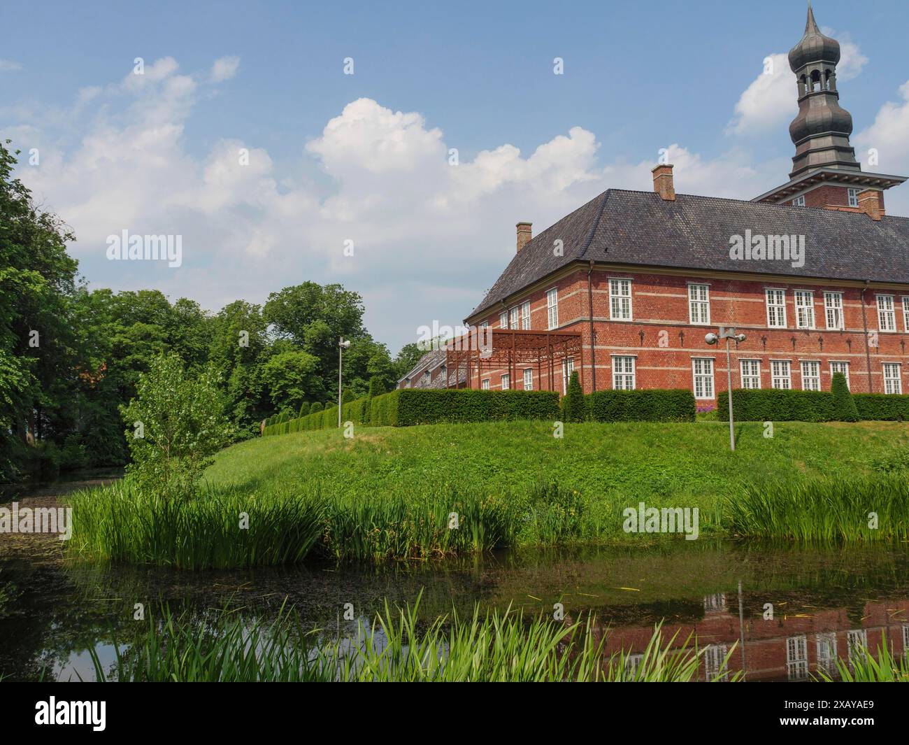 Historic brick house with a tower and beautiful gardens, surrounded by ...